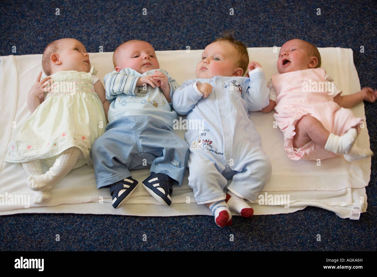 four babies on a mat Stock Photo - Alamy
