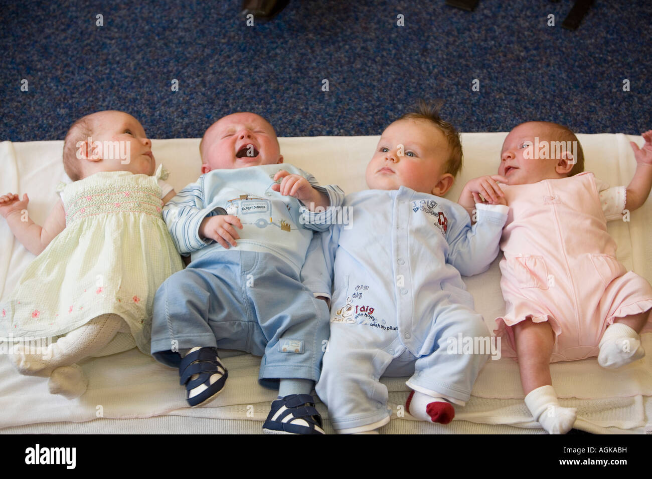 four babies on a mat Stock Photo - Alamy