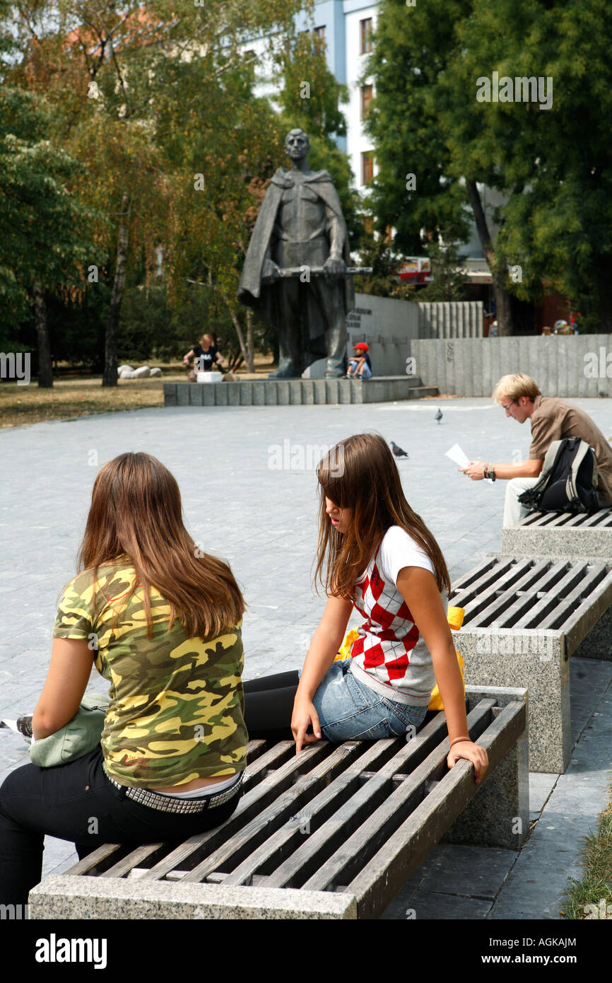 two girls talking on a bench in central Bratislava. Namesti SNP, with ...