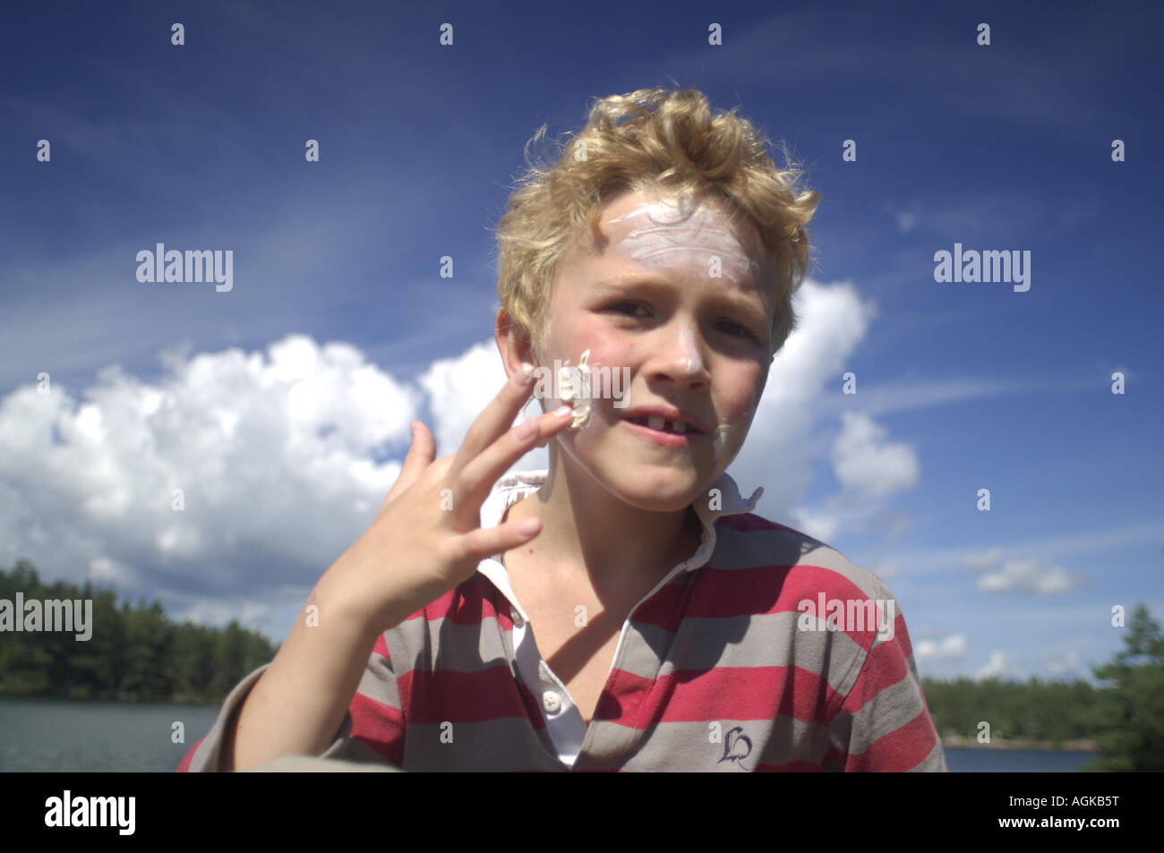 Boy aged 7 having sun cream applied to his face Stock Photo - Alamy