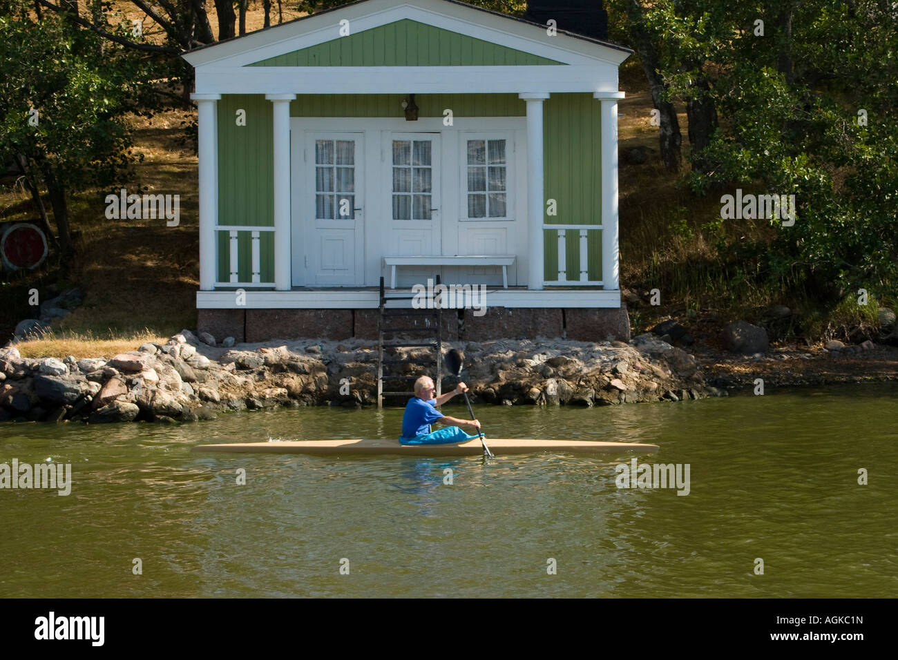 Europe, Finland, Helsinki. Vacation home and man in kayak Stock Photo ...