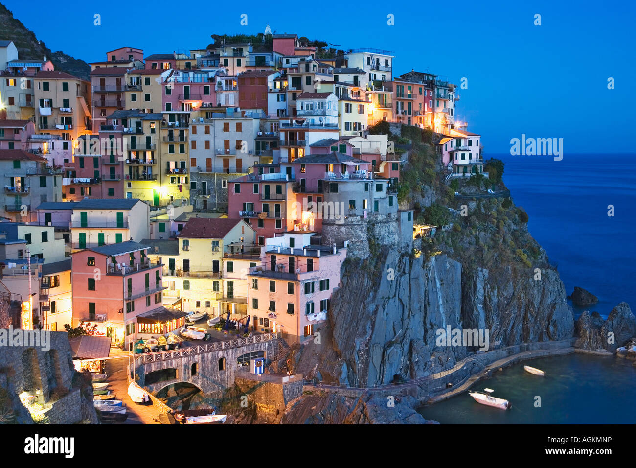 Europe, Italy, Manarola. Dusk falls on a hillside town overlooking the ...