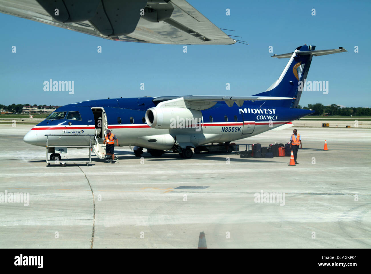 GROUND CREW WORKING ON A MIDWEST PLANE, AS SEEN THROUGH THE WINDOW OF ...