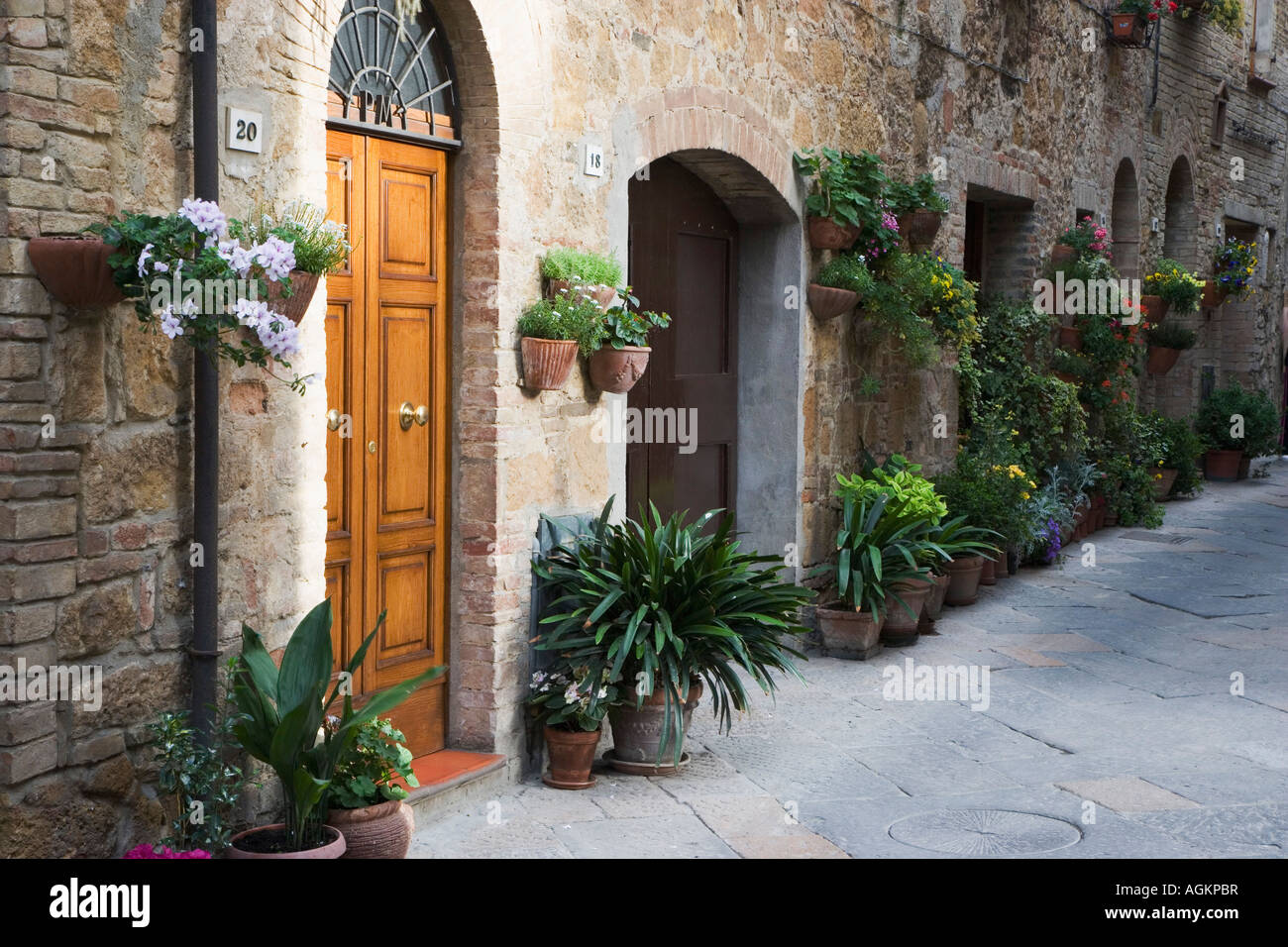 Europe, Italy, Pienza. Flower pots and potted plants decorate a narrow ...