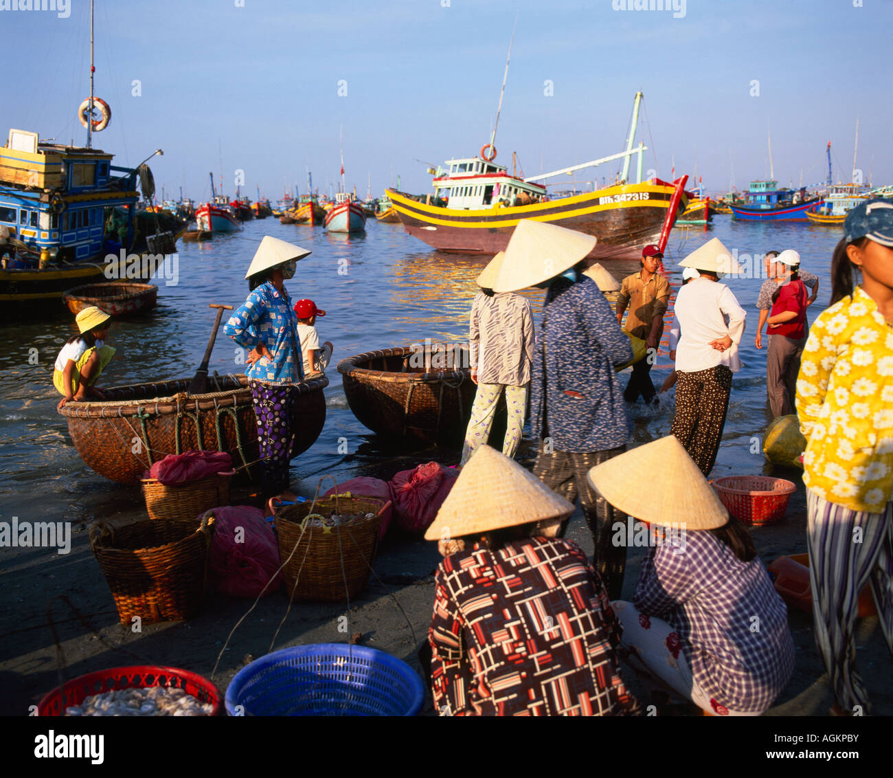 Fishing village people collecting the morning catch from fishing boat ...