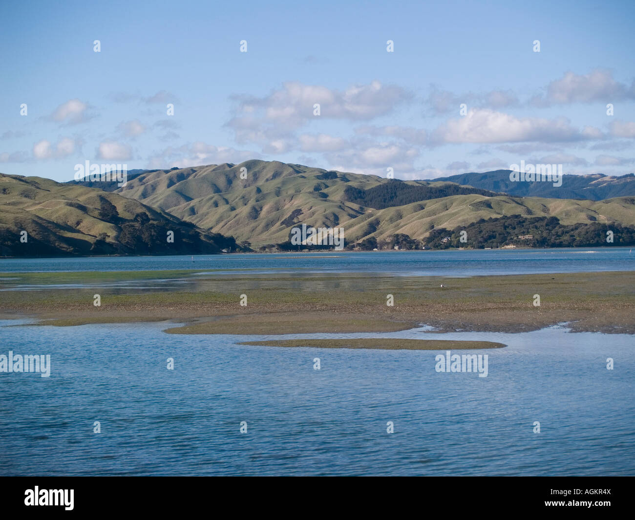 The blue sea sand sky and hills of Pauatahanui Inlet estuary Wellington ...