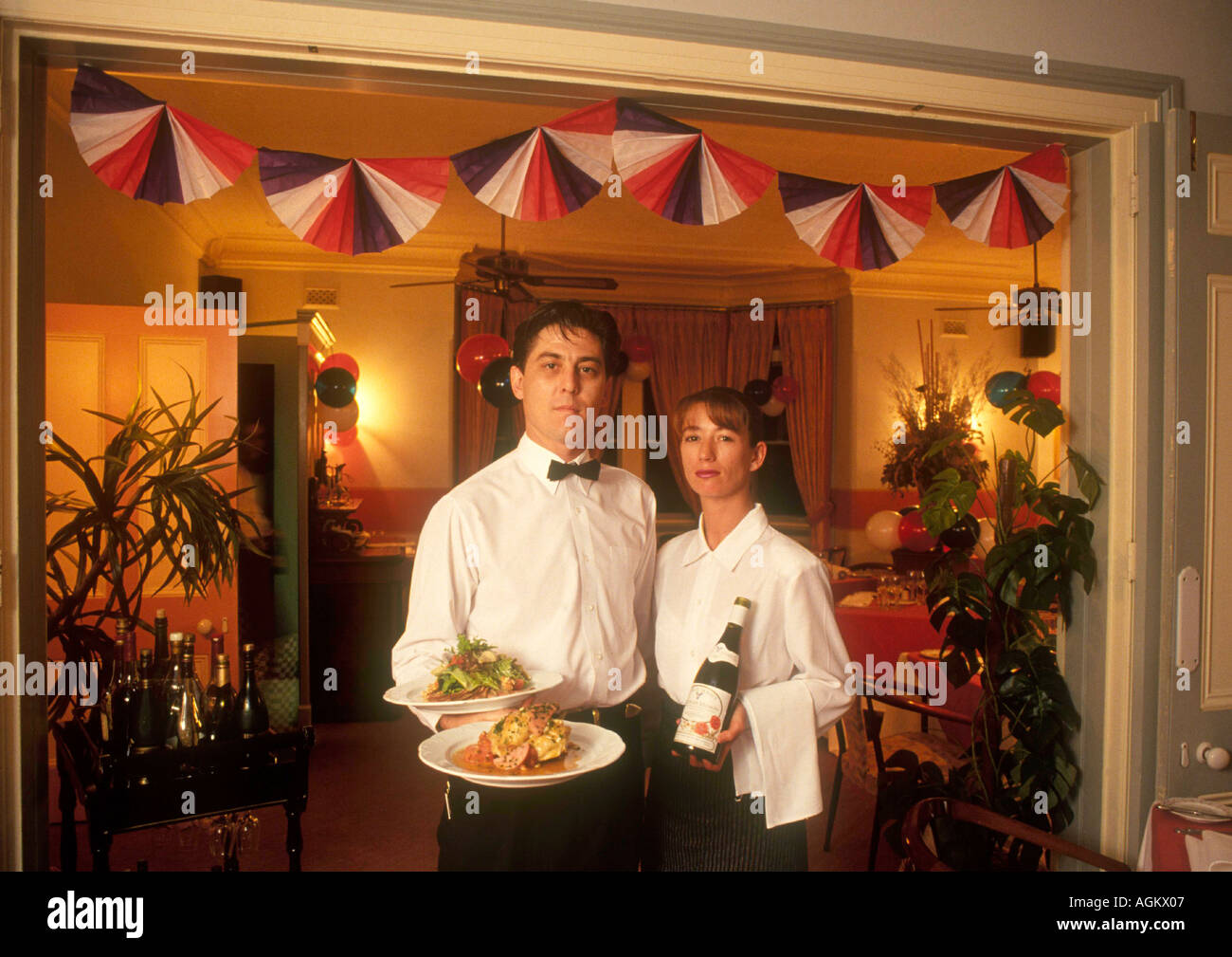 Waiting staff with a restaurant decorated in French style for Bastille ...