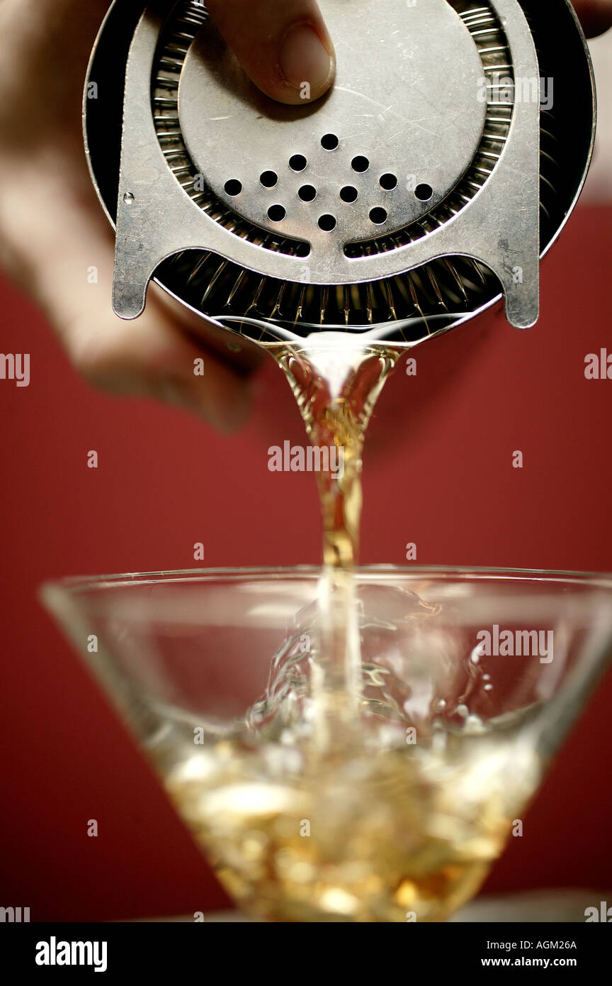 Cocktail being poured into a a martini glass Stock Photo - Alamy