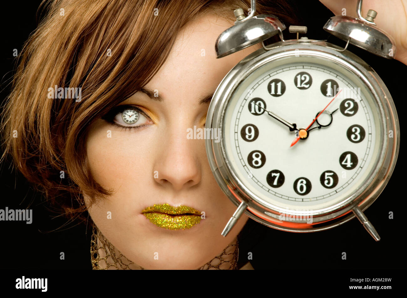woman holding an alarm clock with eye as a clock face Stock Photo - Alamy