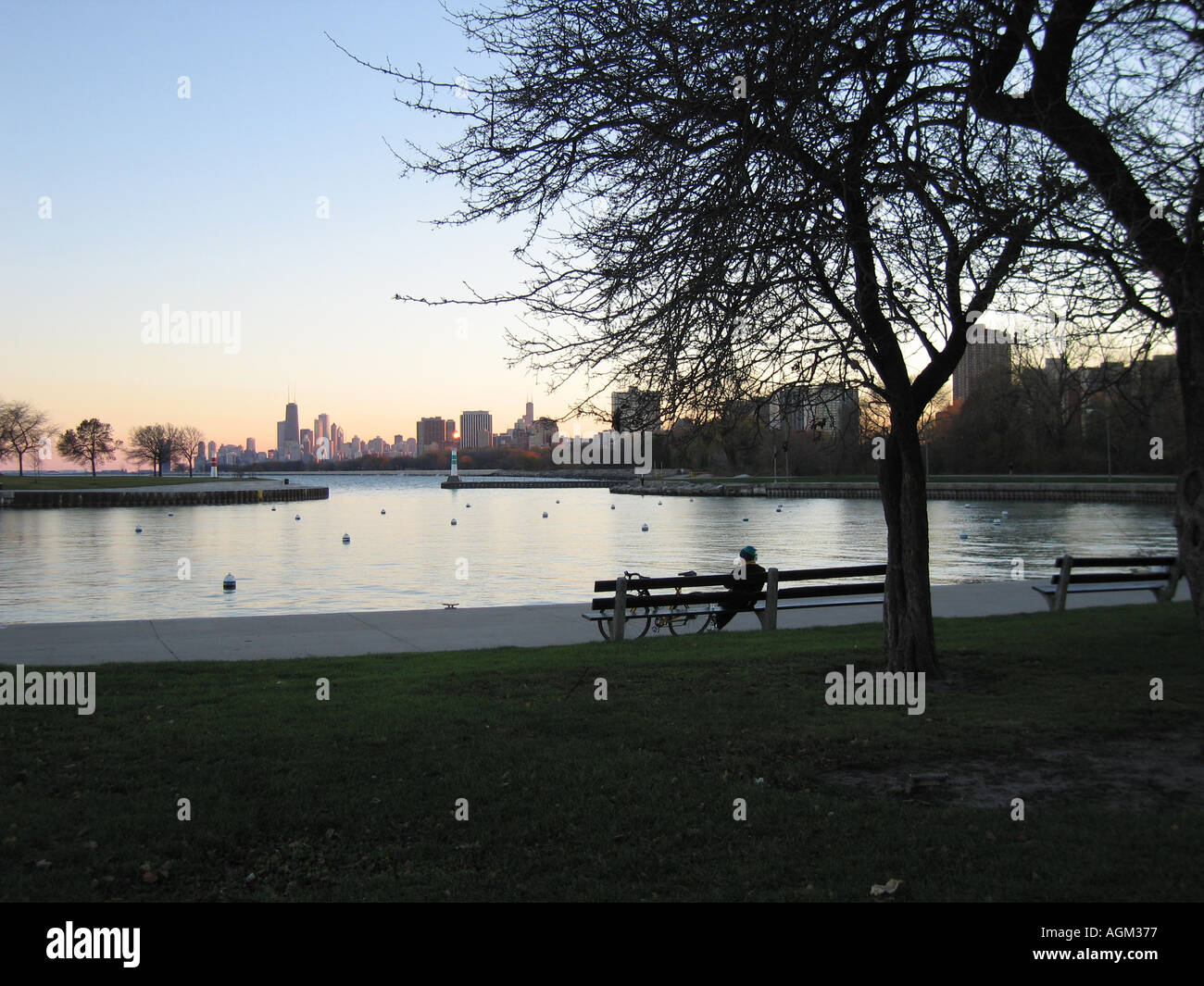 Man watching sunset from a park bench Stock Photo - Alamy