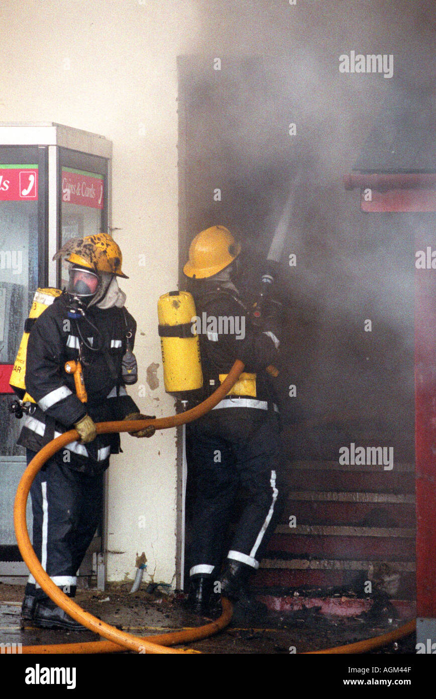 Two Firefighters enter a burning building, Britain UK Stock Photo - Alamy
