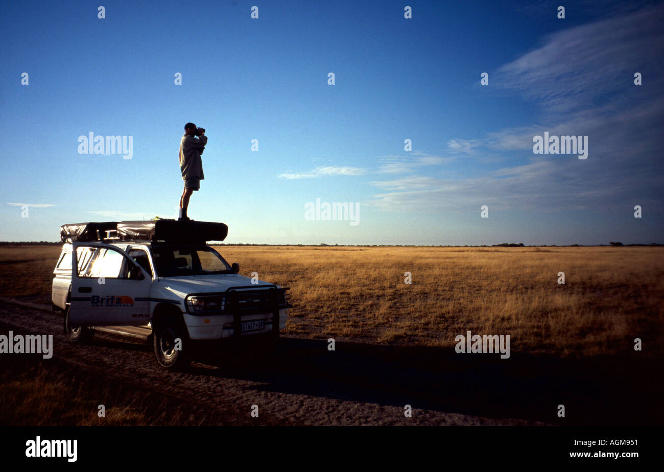 AFRICA A guide scans the wilderness Stock Photo - Alamy
