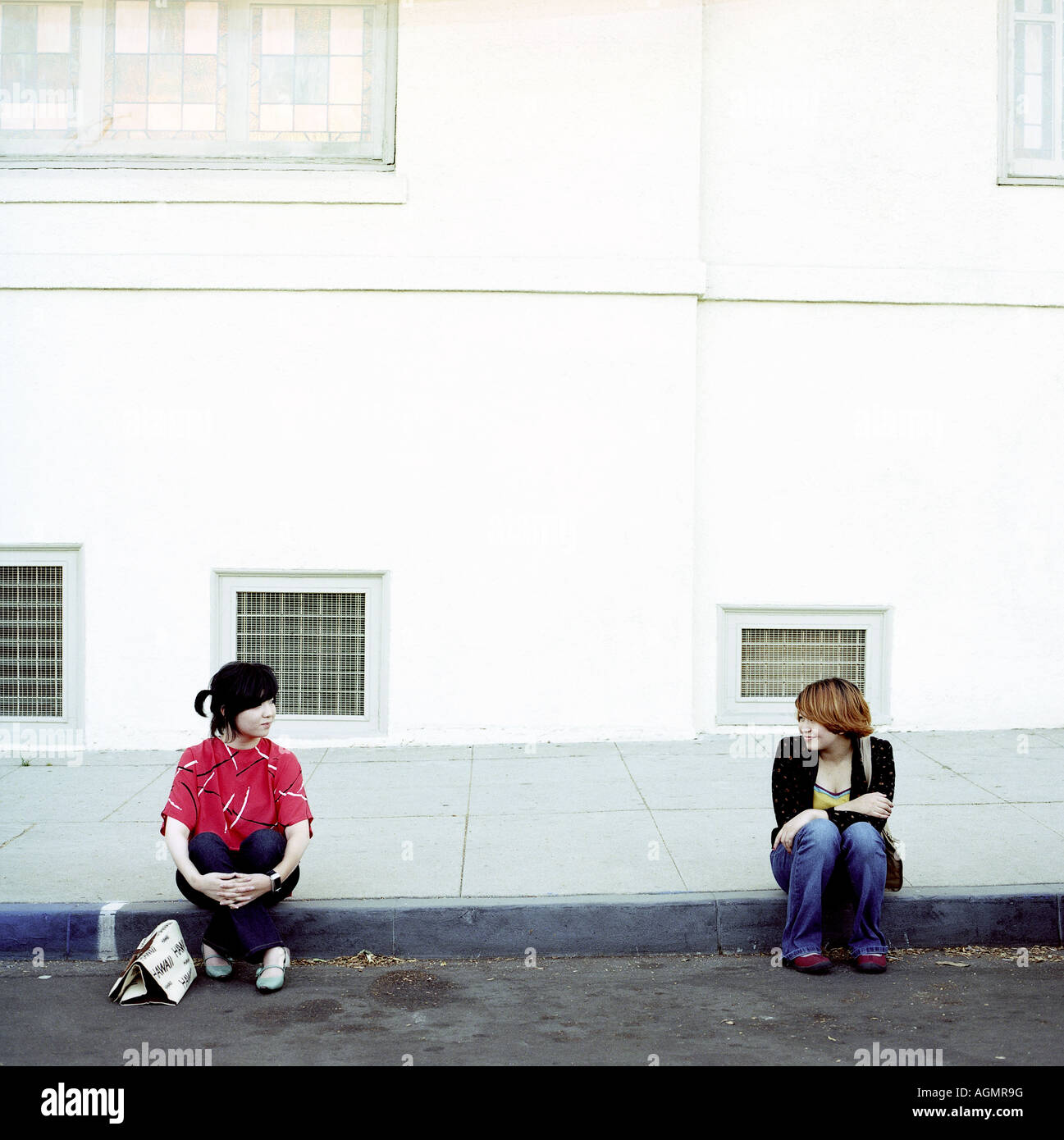 Young woman sitting on curb hi-res stock photography and images - Alamy