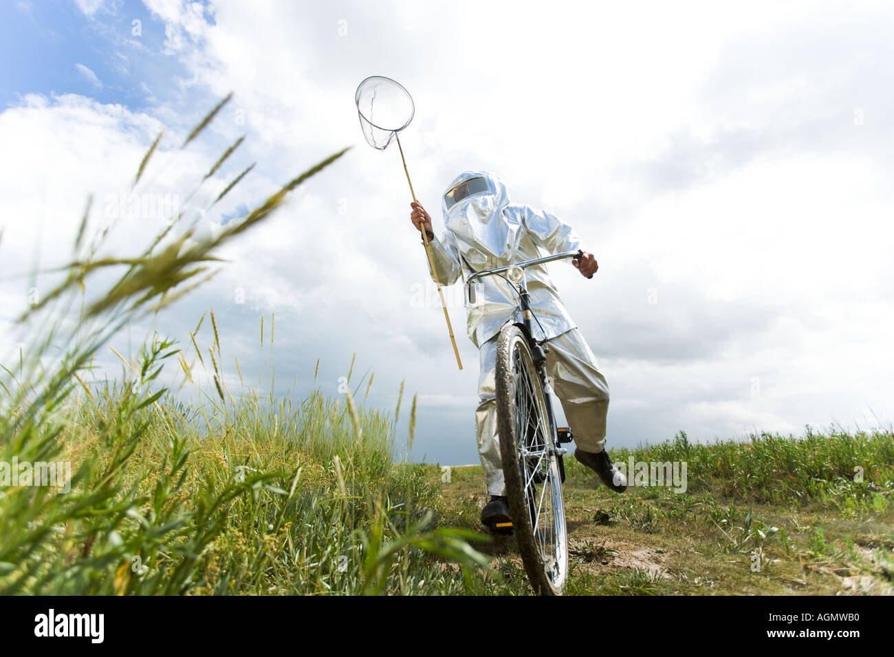 Fire fighter in mask on an old bicycle catching insects butterflies on ...