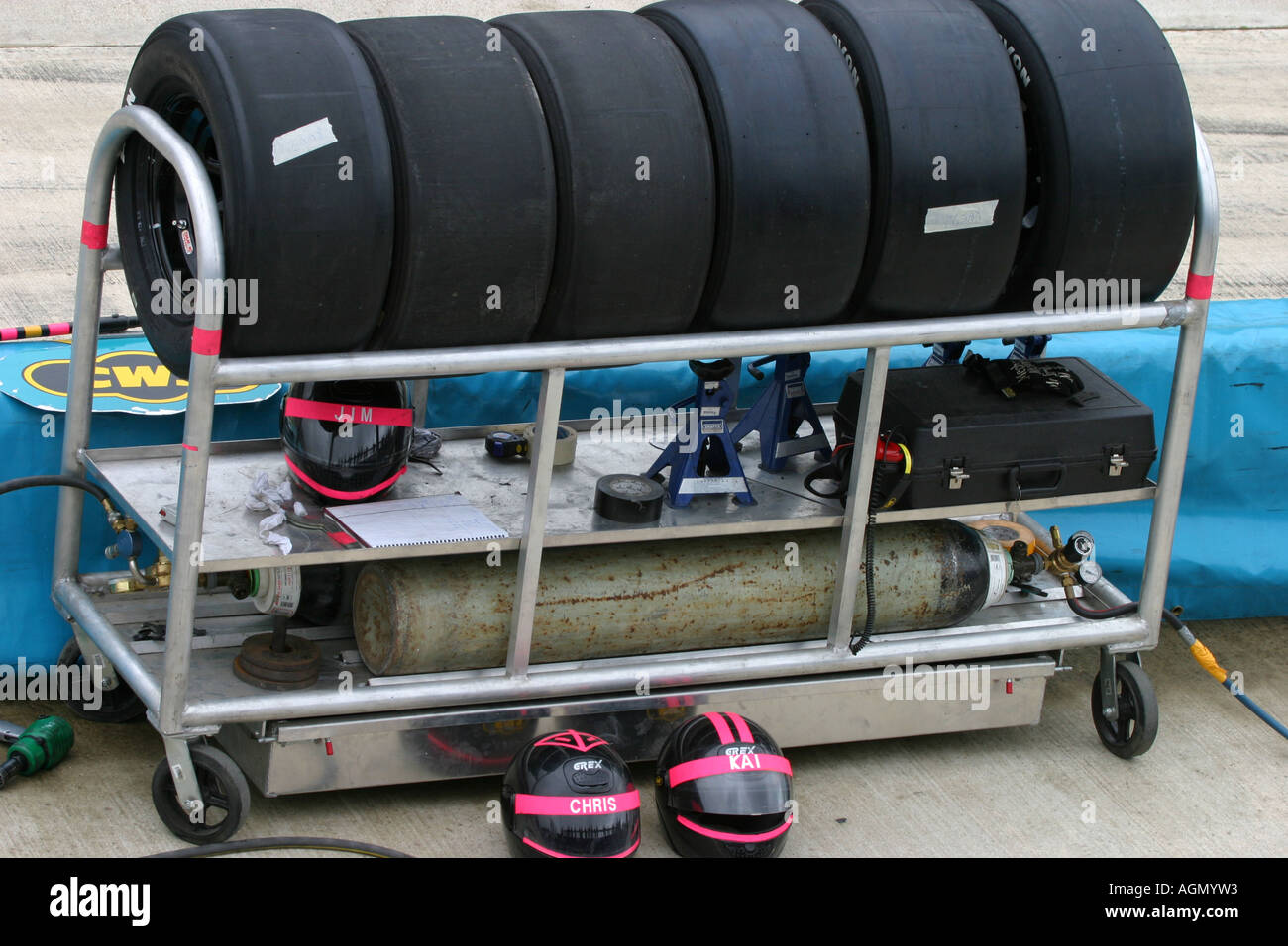 Race car wheels and slick tyres on a rack Stock Photo - Alamy