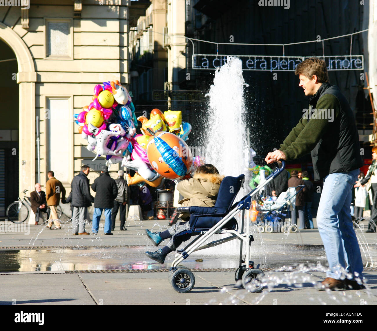 Father pushing child in pram watching balloons Piazza Reale Turin Italy ...