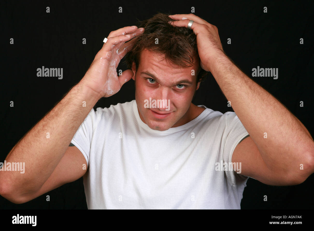 Fit handsome young 20s male man applying hair care product hair gel ...