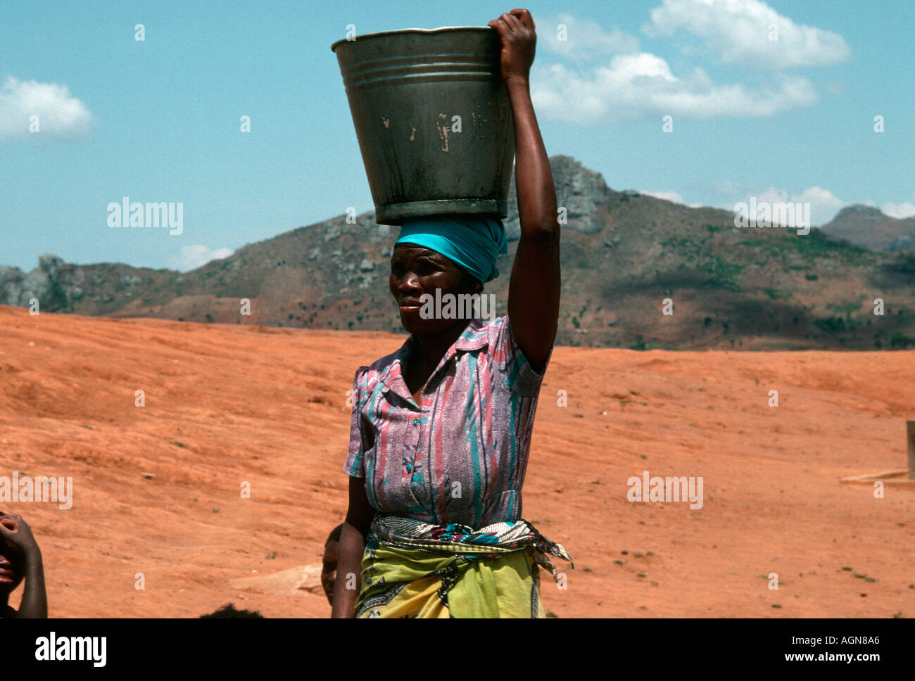 Woman carrying water bucket on head Near Mozambique refugee settlement ...
