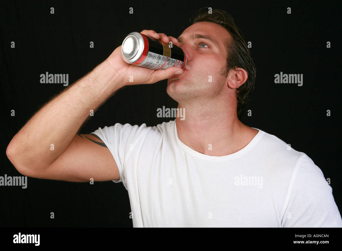 Young man in white t shirt binge drinking abusing alcohol drinks ...
