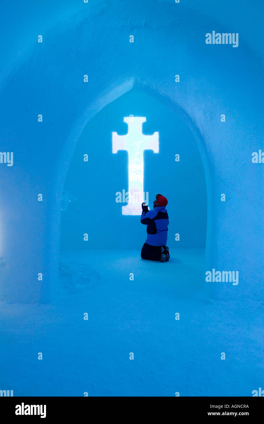 Woman praying at the cross inside the Ice Church at the Ice hotel ...