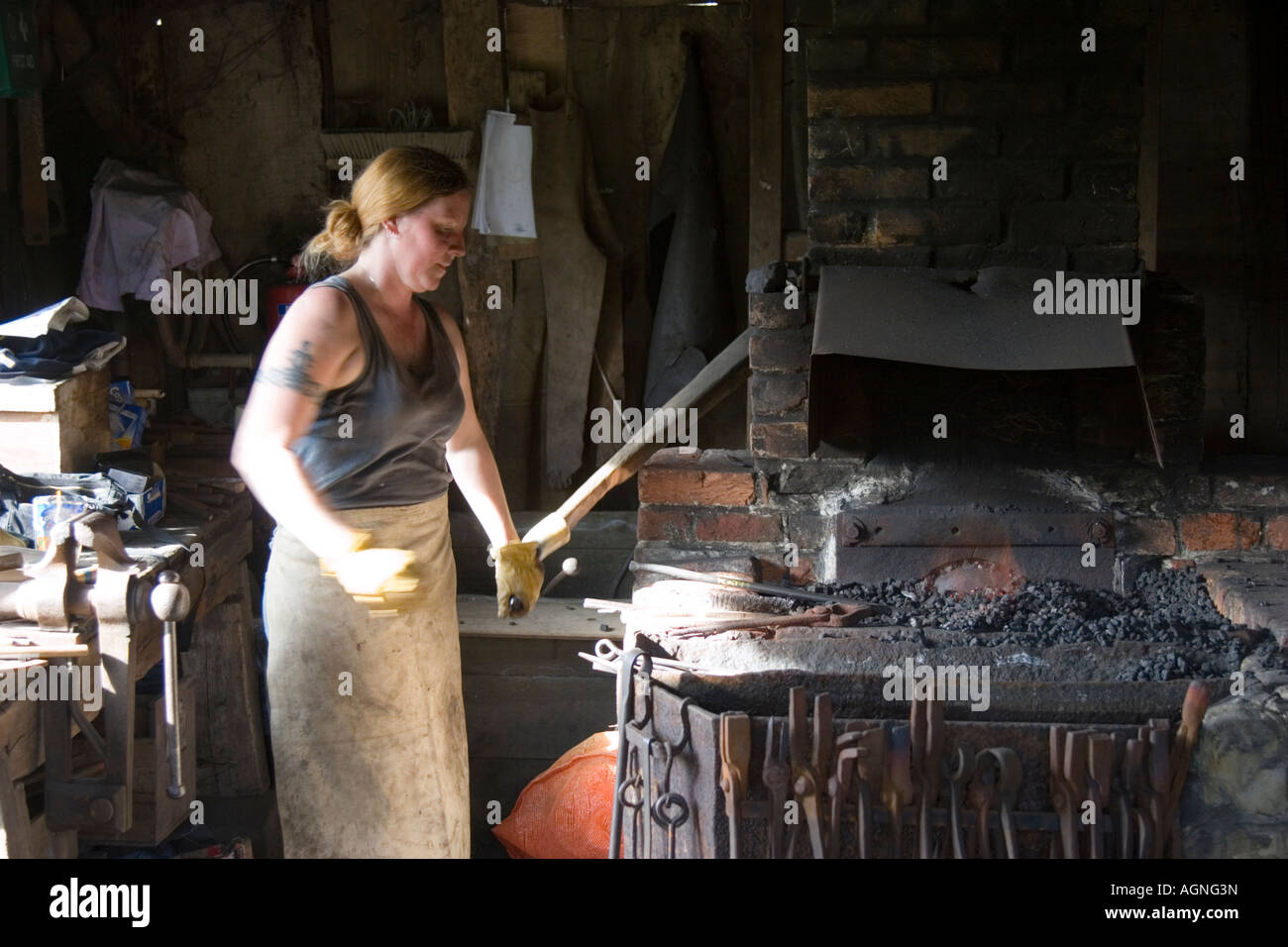 Blacksmith s forge and blacksmith working at an anvil Stock Photo - Alamy