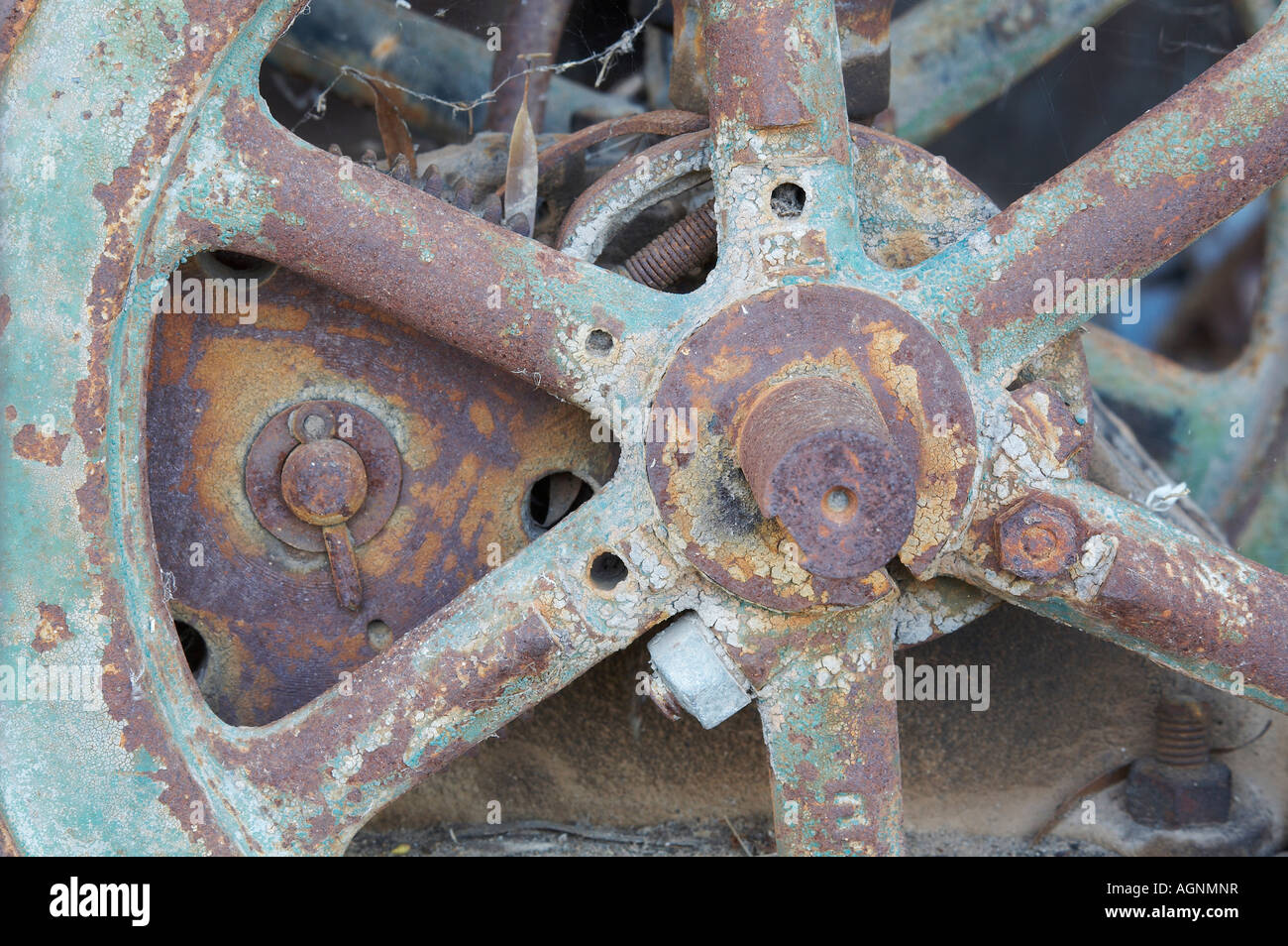 close up of corroded spokes on an example of vintage farm machinery ...