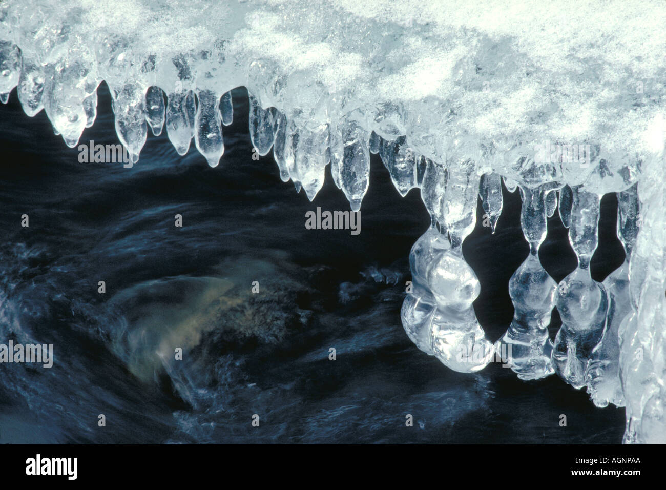 Icy water flows under frozen snow Stock Photo - Alamy