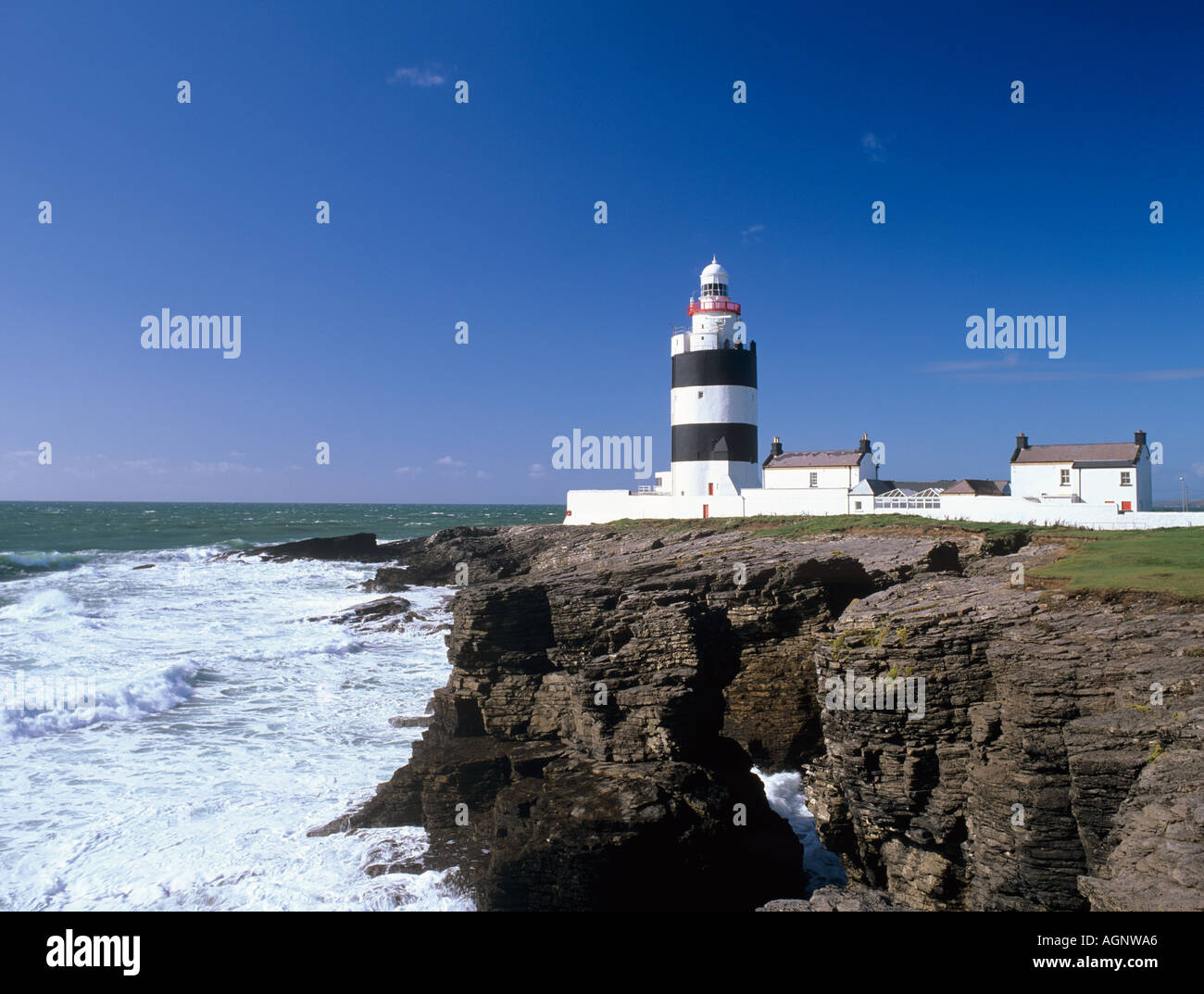 Old 19th nineteenth century Hook Head Lighthouse on cliffs seen from ...