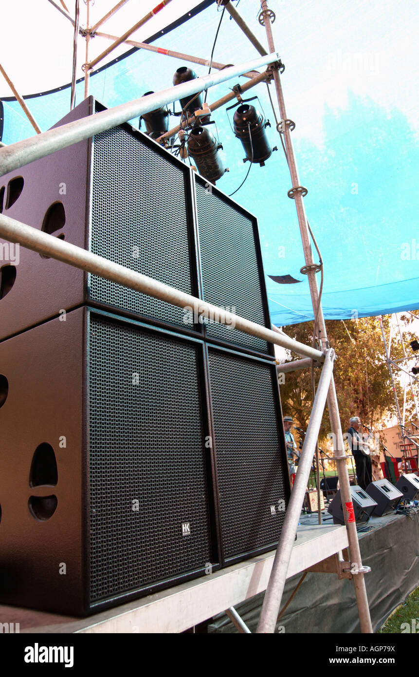 A Large bank of Loudspeakers on the side of a stage at an outdoor music ...