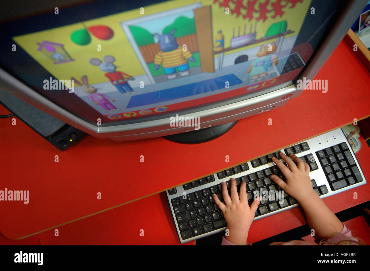 A childs hands on the keyboard of a computer, playing a game in a ...