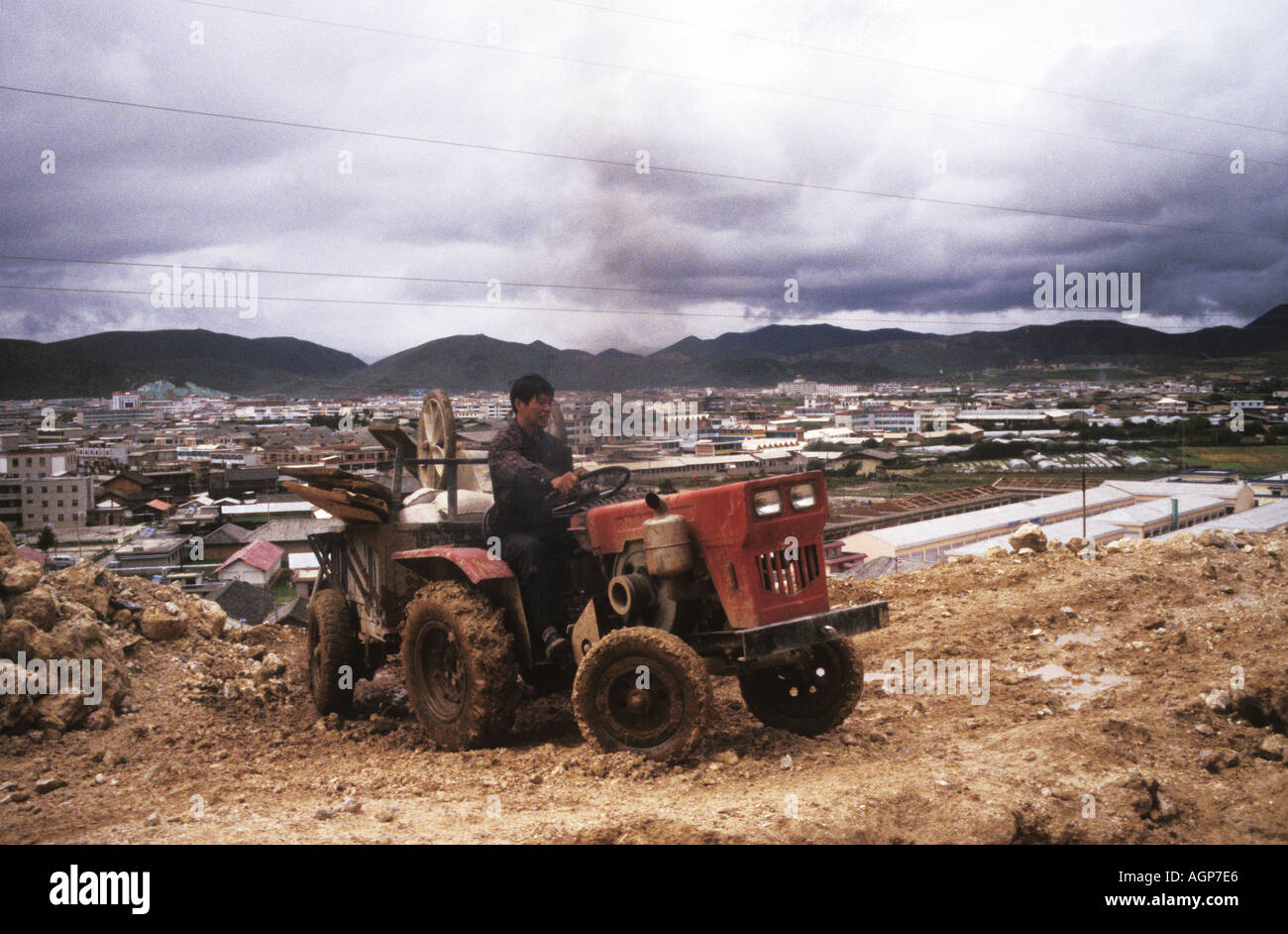 Chinese workers using a tractor to build a road in Zhongdian County ...