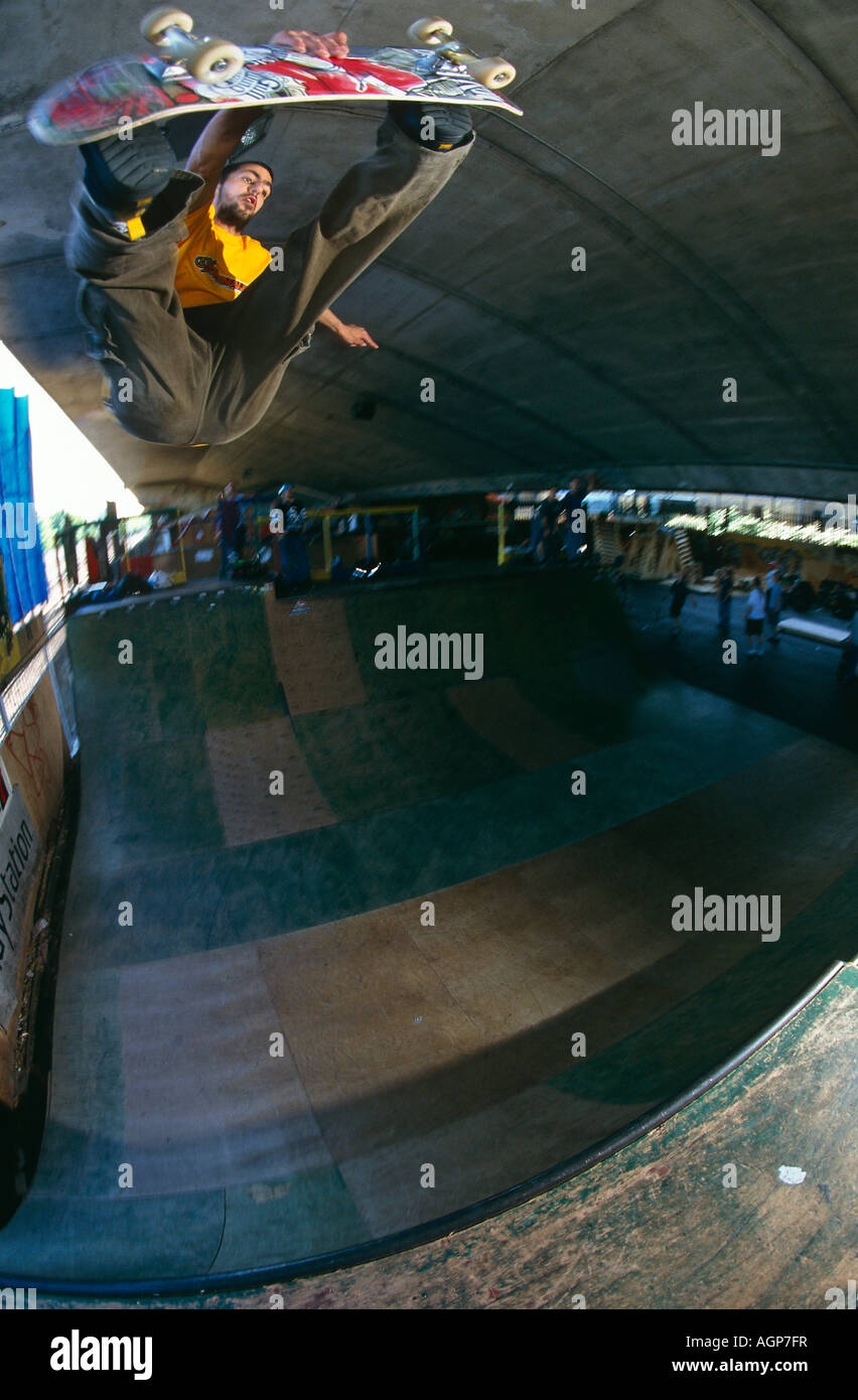 Skateboarder performs trick in wooden skatepark Stock Photo - Alamy