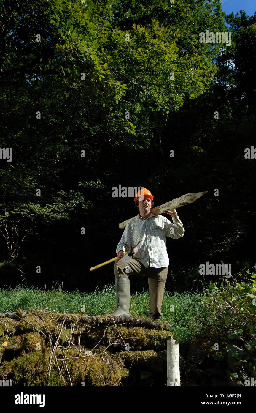 A man standing holding a fence post on a National Trust working holiday ...