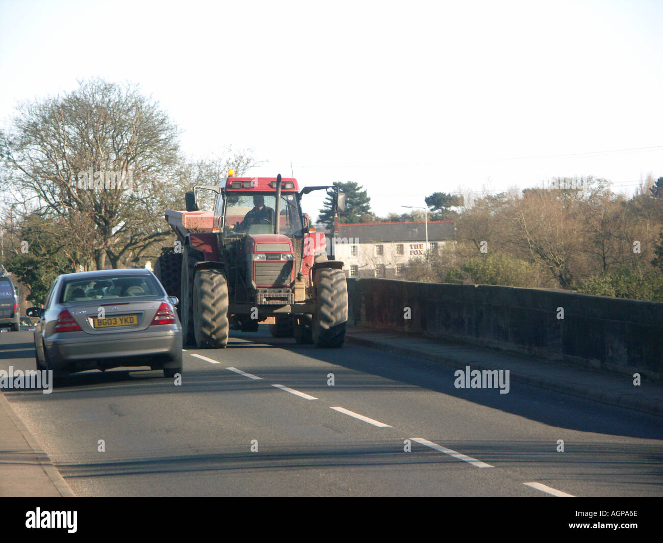 Large tractor passing a car on a road bridge Stock Photo - Alamy