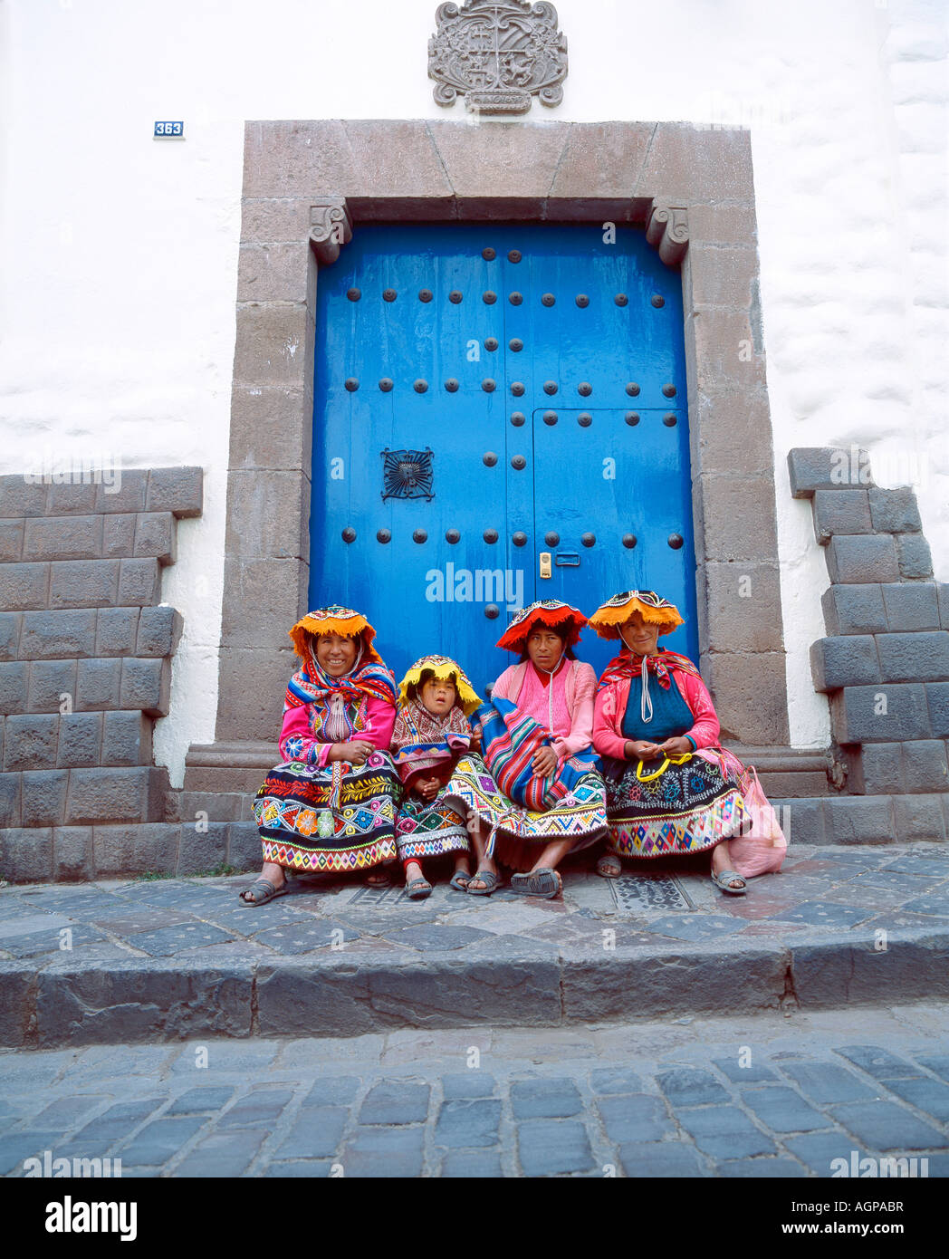 South America, Peru, Cusco. Young girl and three Peruvian women rest on ...