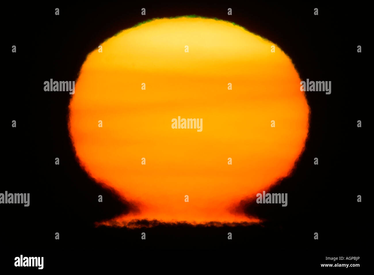 USA, Alaska, Homer. Sun at sunset distorts to look like a nuclear ...