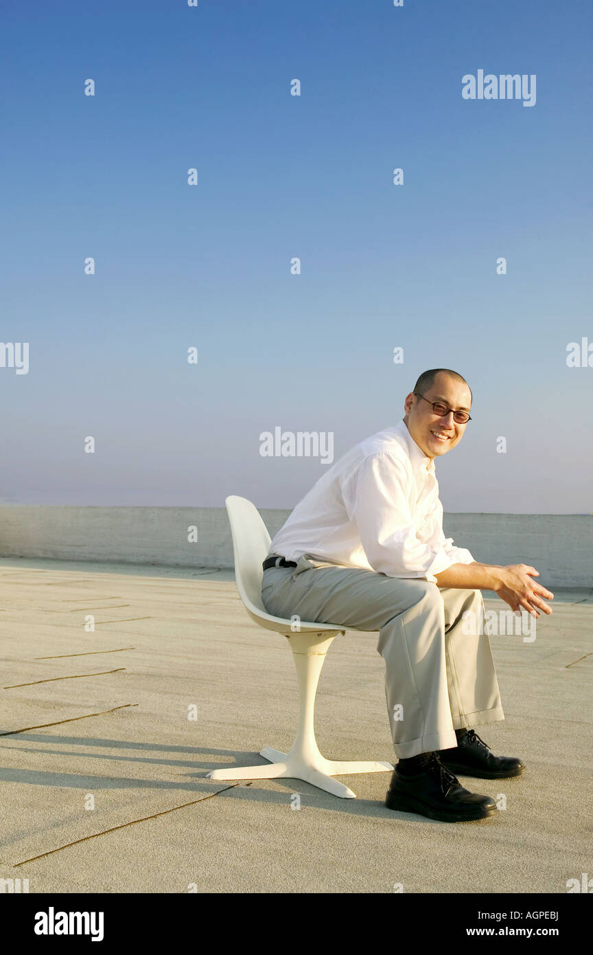 Man Sitting on Roof Stock Photo - Alamy