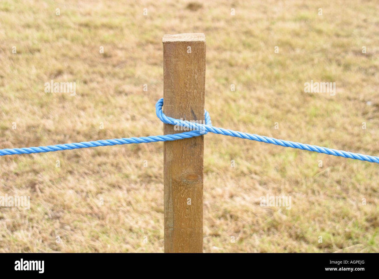 Rope barrier fence wrapped around wooden fence post Stock Photo - Alamy