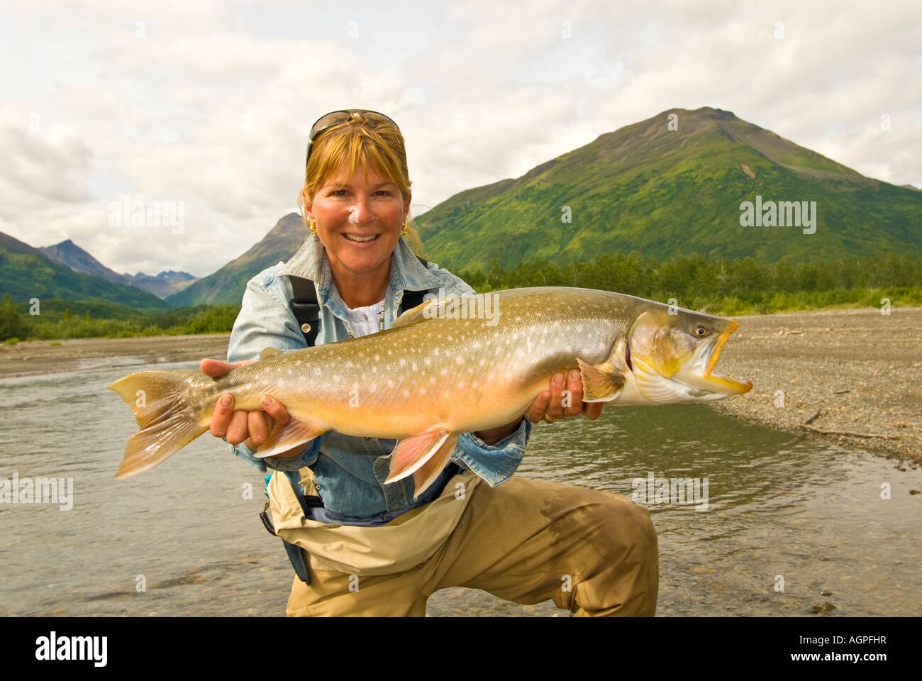 Alaska Southwest Happy woman fisherman holding record Arctic Char ...