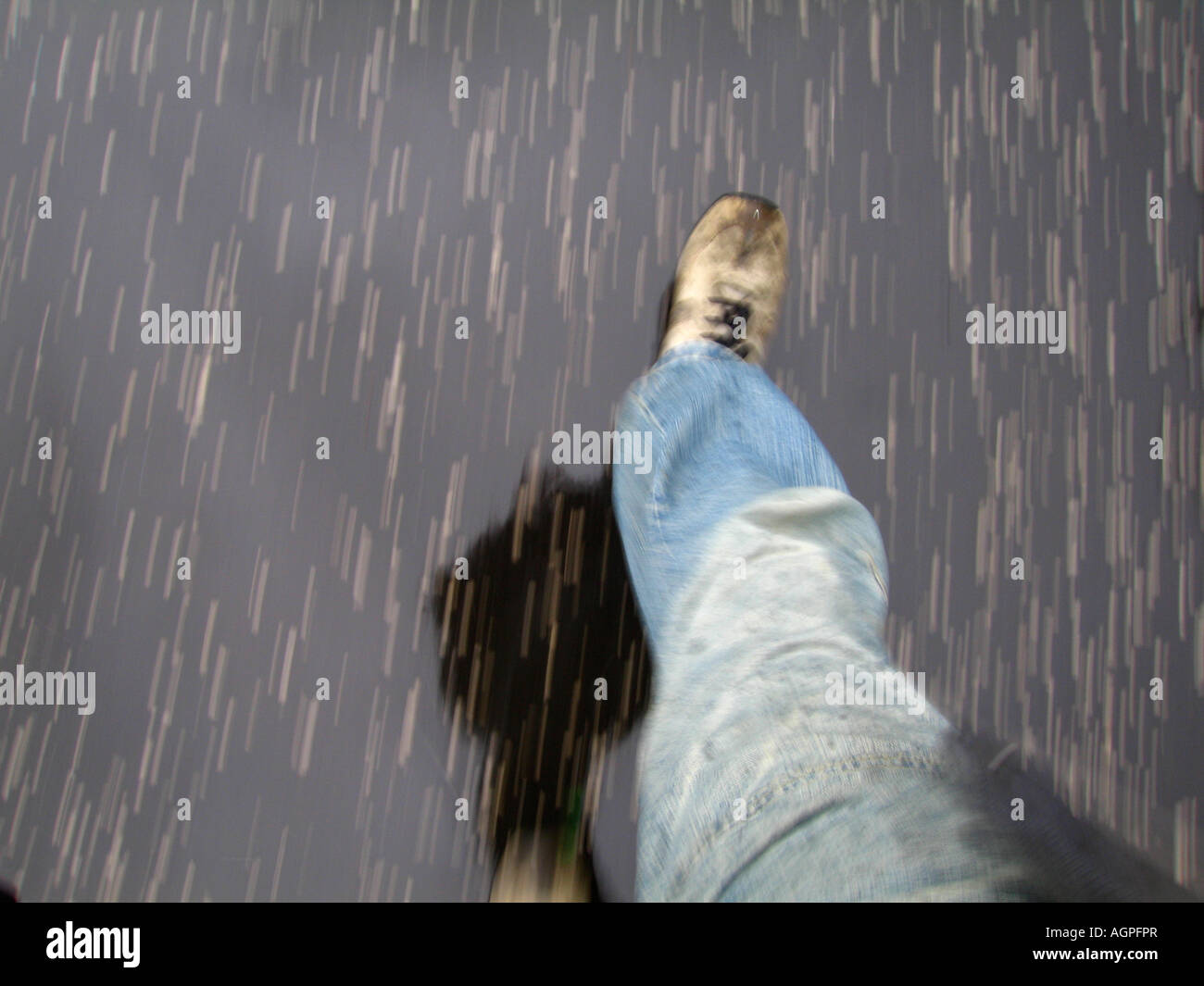 Mans leg striding out against motion blur pavement Stock Photo - Alamy