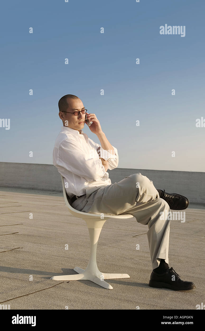 Man on Phone Sitting in Modern Chair Stock Photo - Alamy