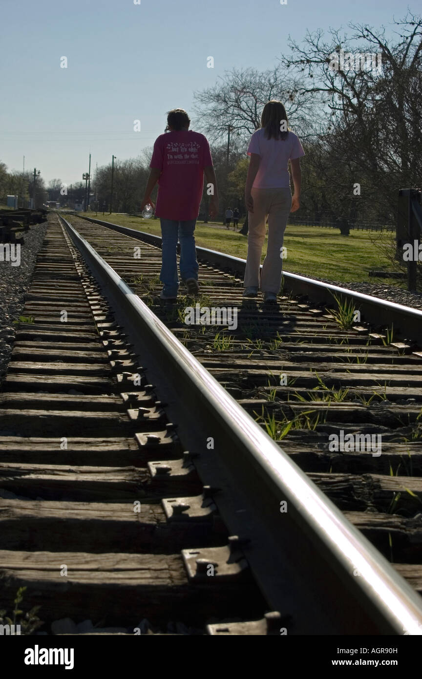 Two girls walking on the train tracks Stock Photo - Alamy
