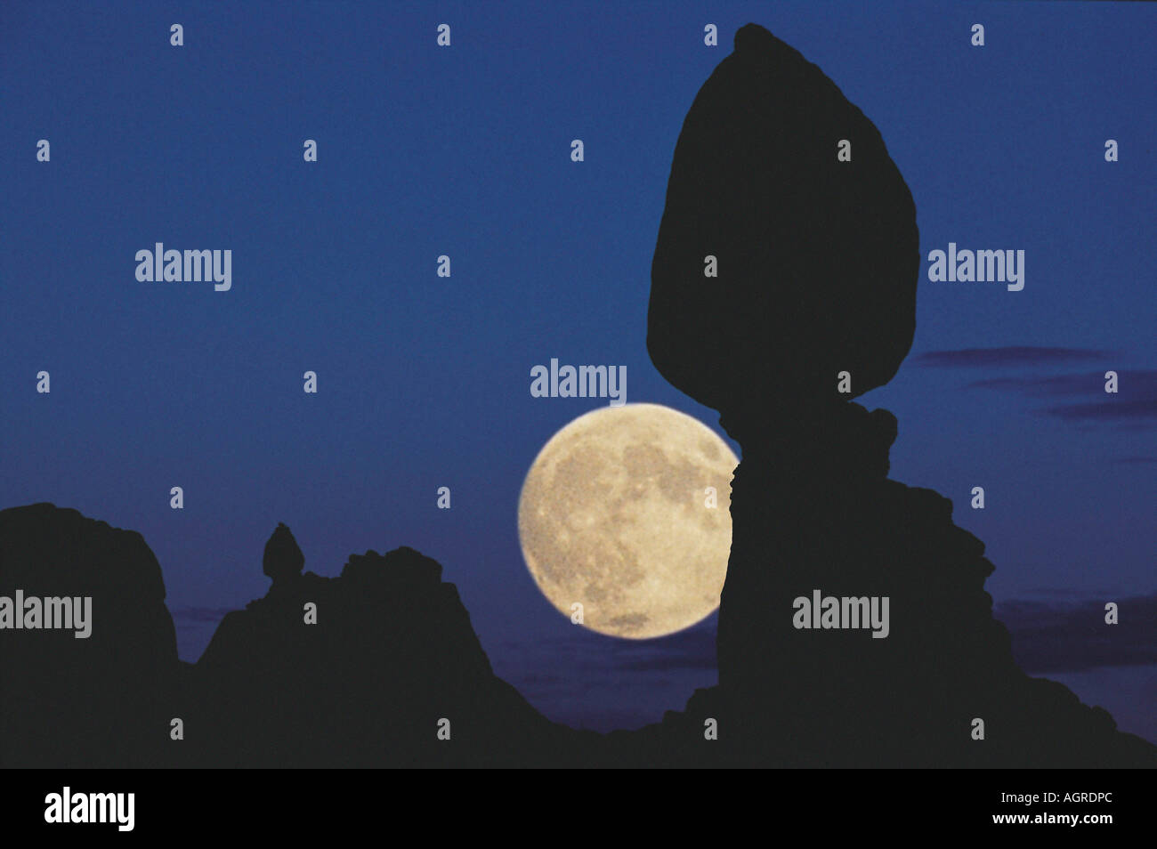 Fullmoon behind rock Stock Photo - Alamy