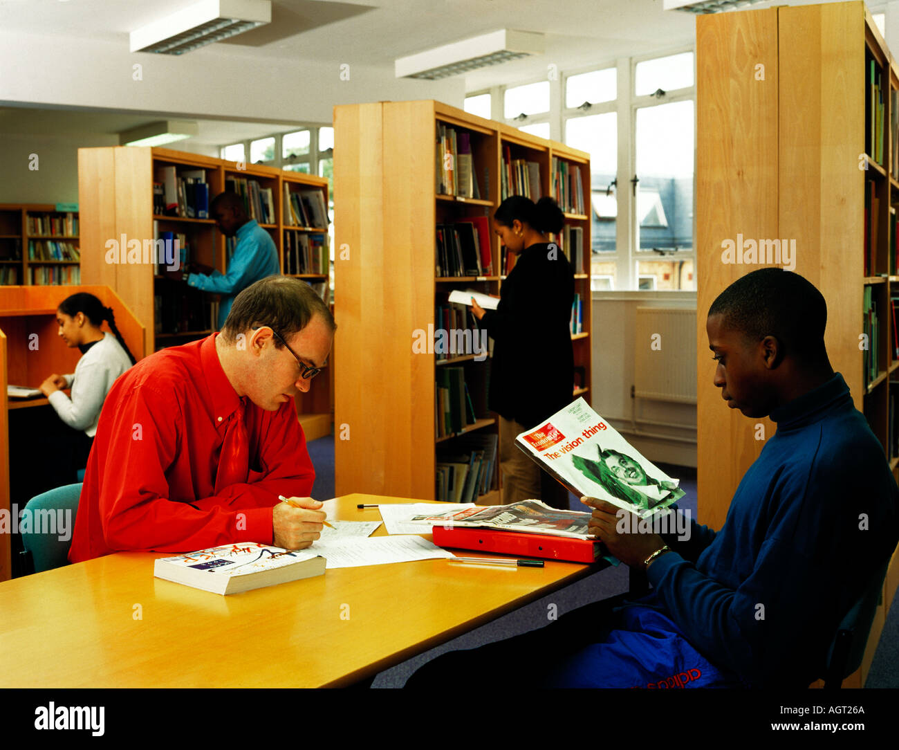 Two men reading in a library One Black one Asian Stock Photo - Alamy