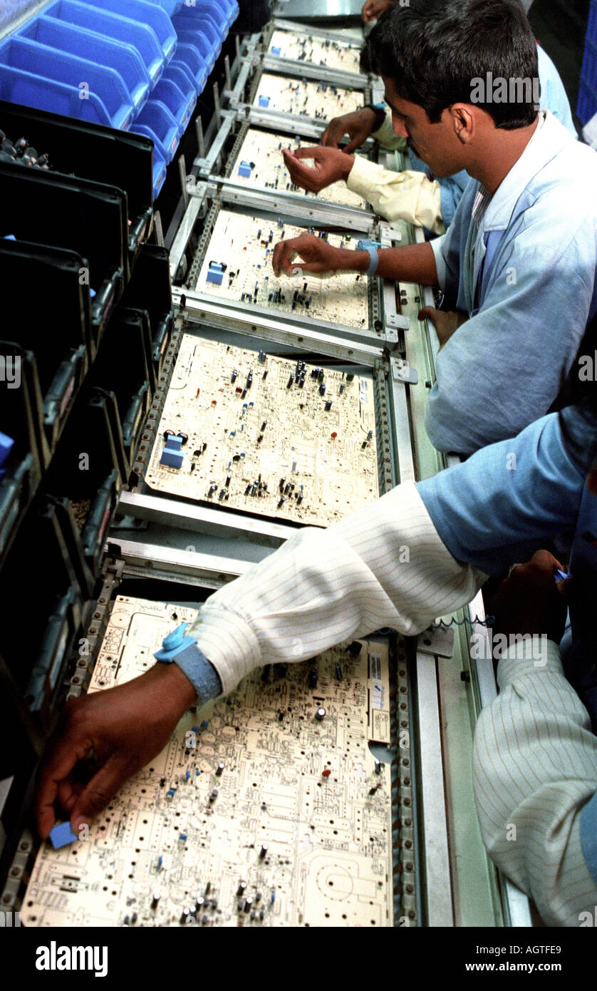 Laborer putting together a computer at a computer manufacturing plant ...