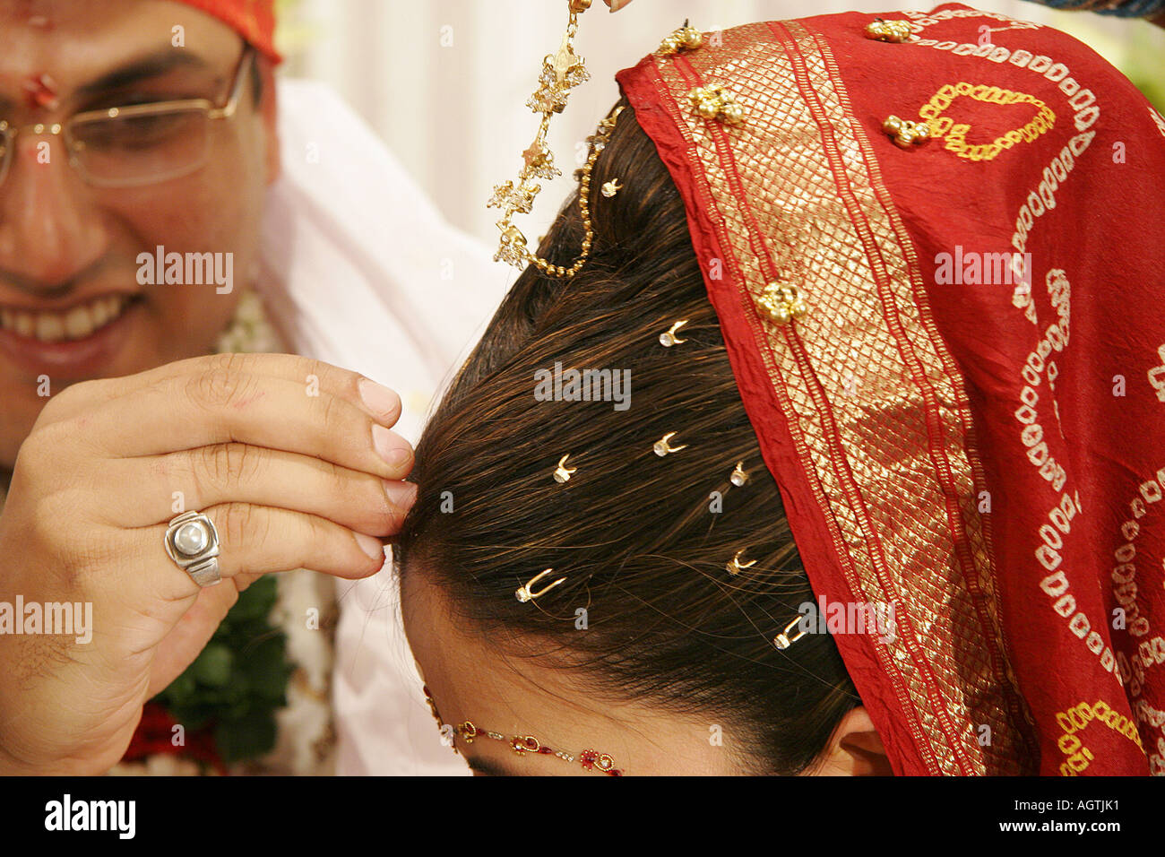 Indian Gujarati Bridegroom putting red powder called Sindoor on brides ...