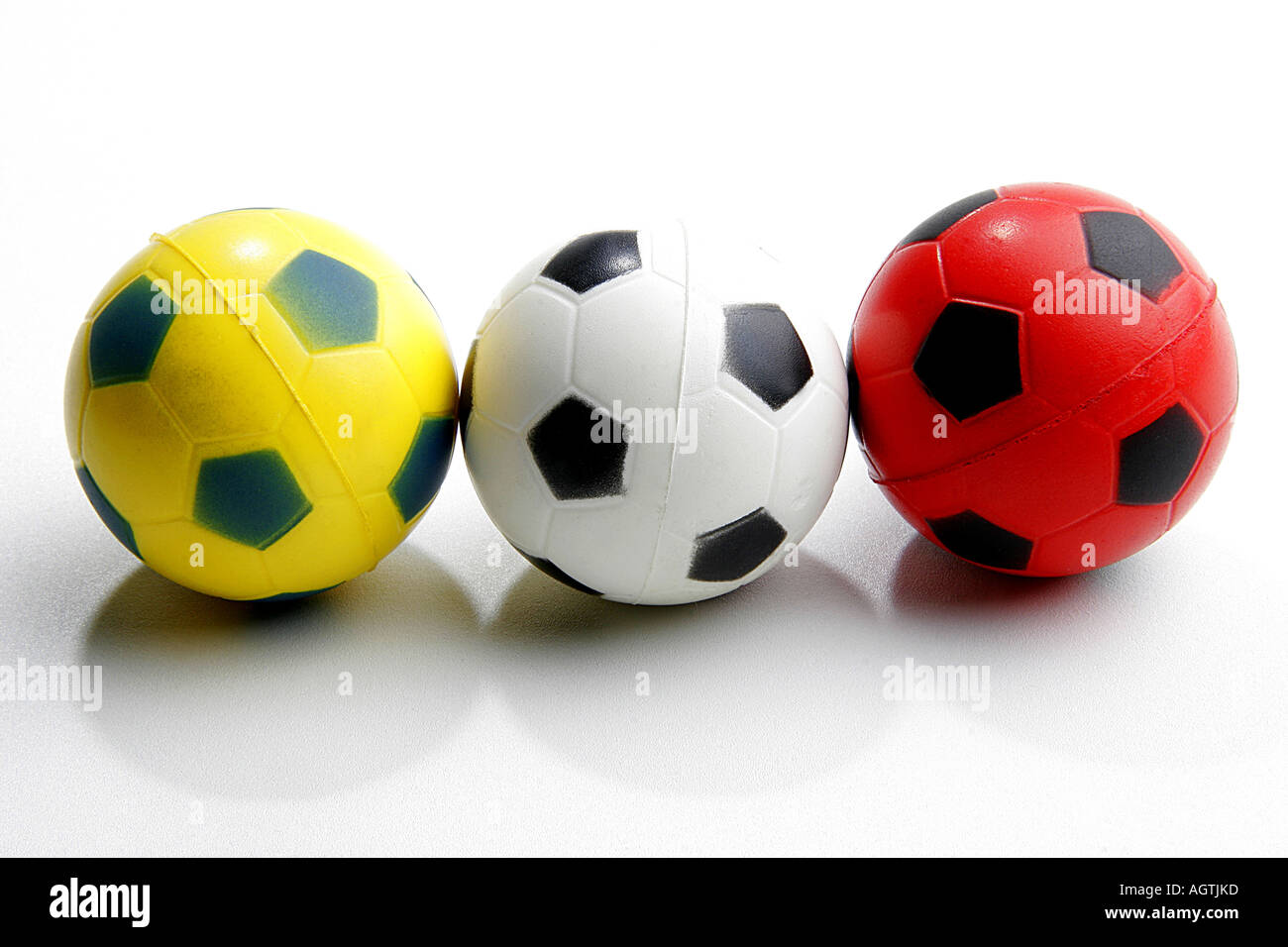 Three footballs yellow and blue white and black red and black on white ...
