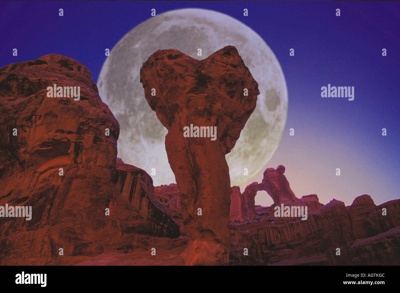 Fullmoon behind rock Stock Photo - Alamy