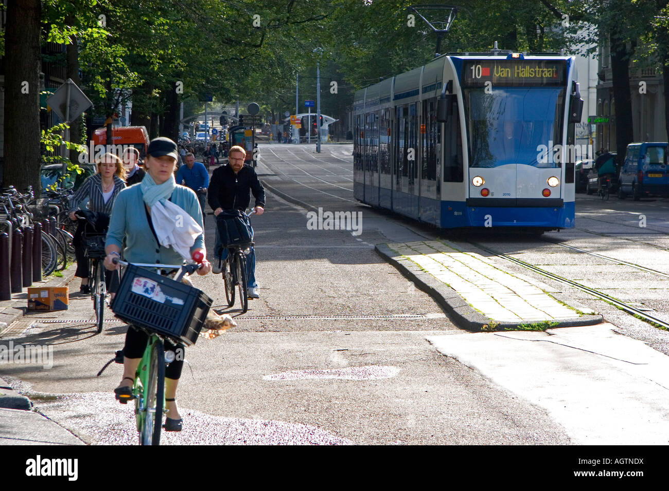 Morning commuters ride bicycles along side a tram line in Amsterdam ...
