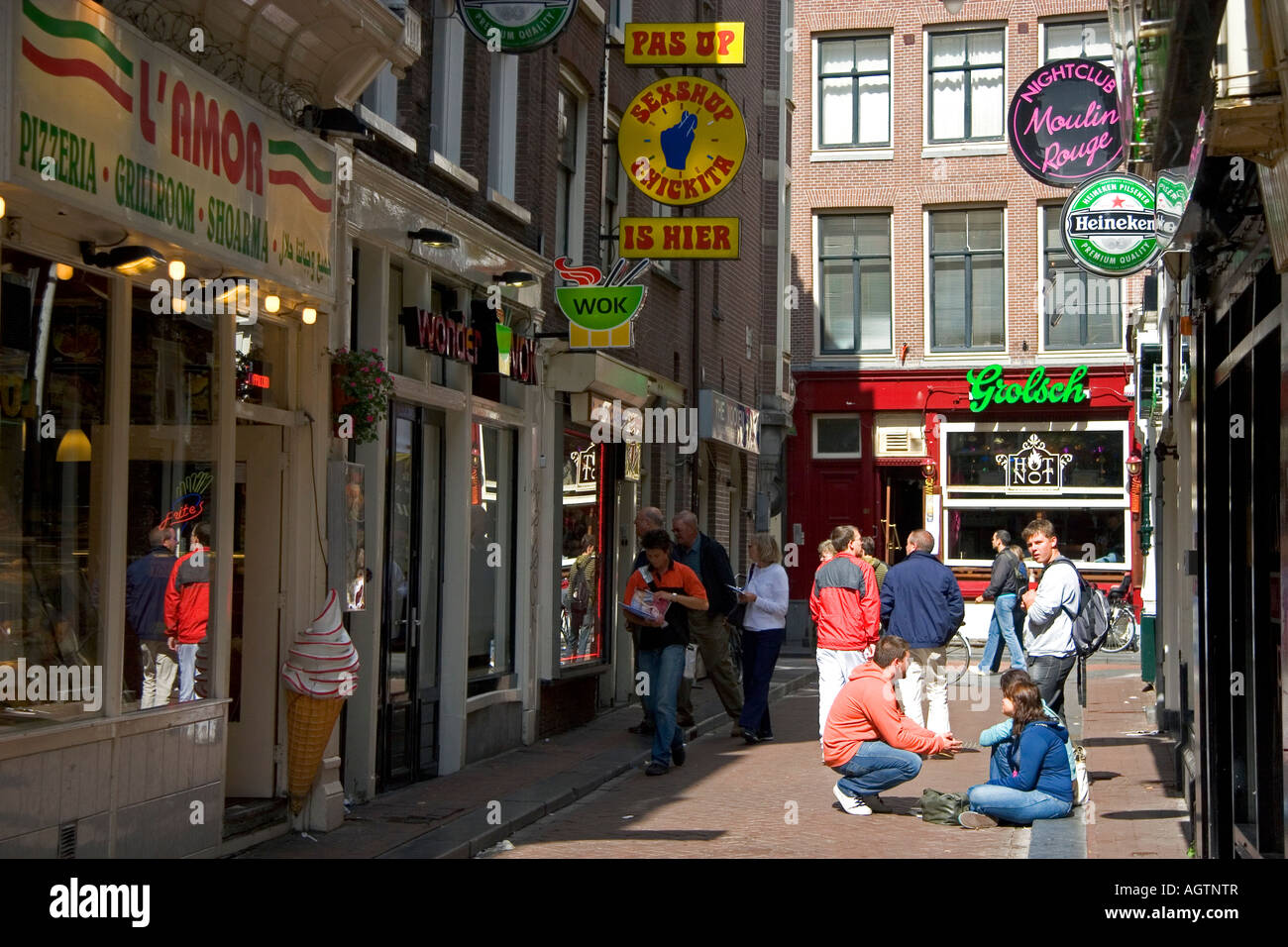 People and store fronts on a walking street in the Red Light District ...